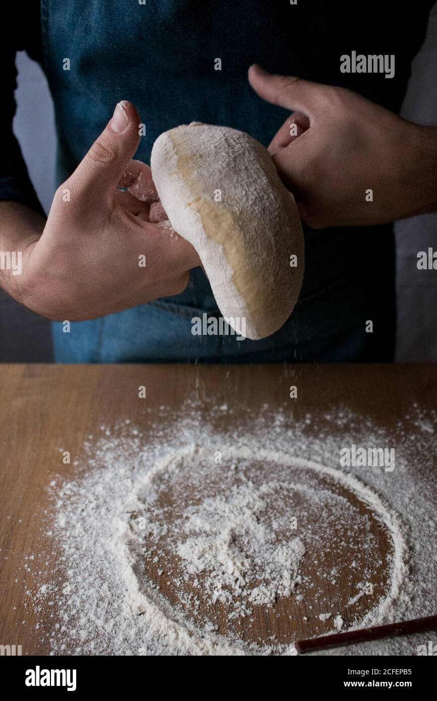 unrecognizable cook shaping fresh dough with flour while cooking Rosca ...