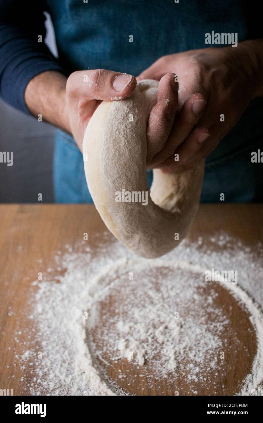 unrecognizable cook shaping fresh dough with flour while cooking Rosca ...