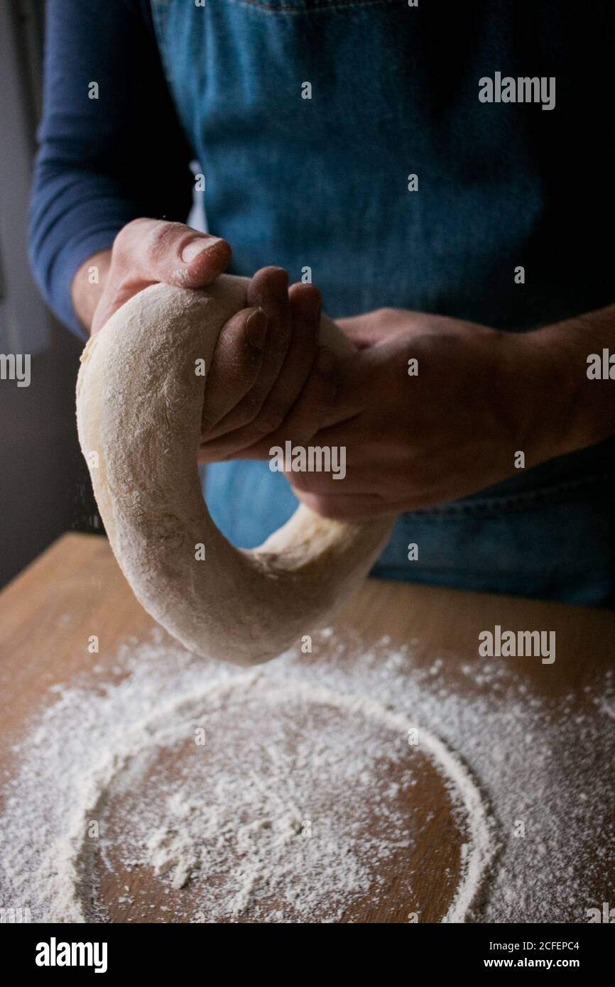 unrecognizable cook shaping fresh dough with flour while cooking Rosca ...