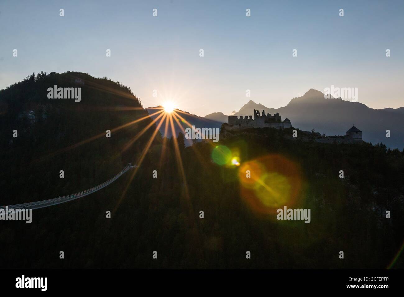 Vivid morning sun shining on cloudless sky over mountain ridge and old ...