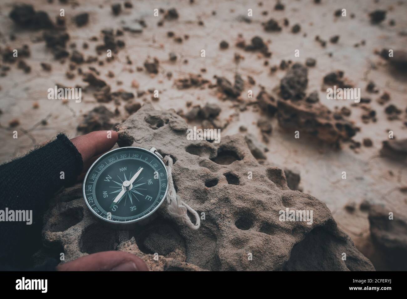 Compass in hand on dry desert area Stock Photo - Alamy