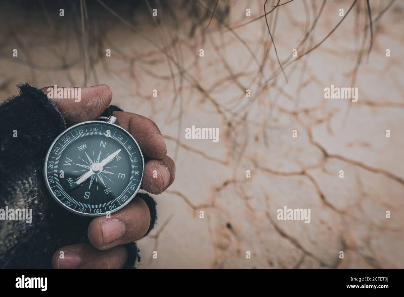 Compass in hand on dry desert area Stock Photo - Alamy