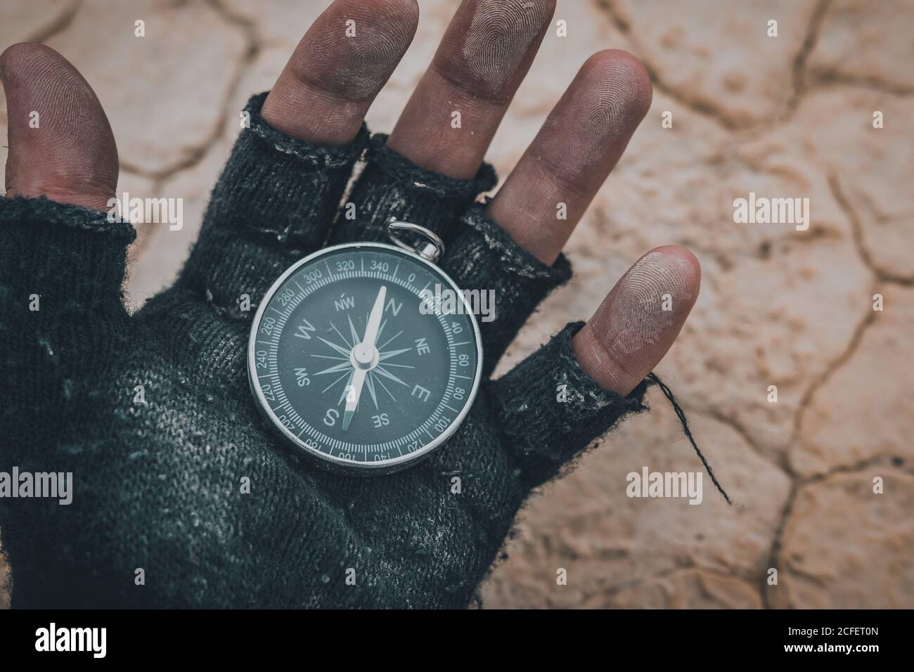 Compass in hand on dry desert area Stock Photo - Alamy
