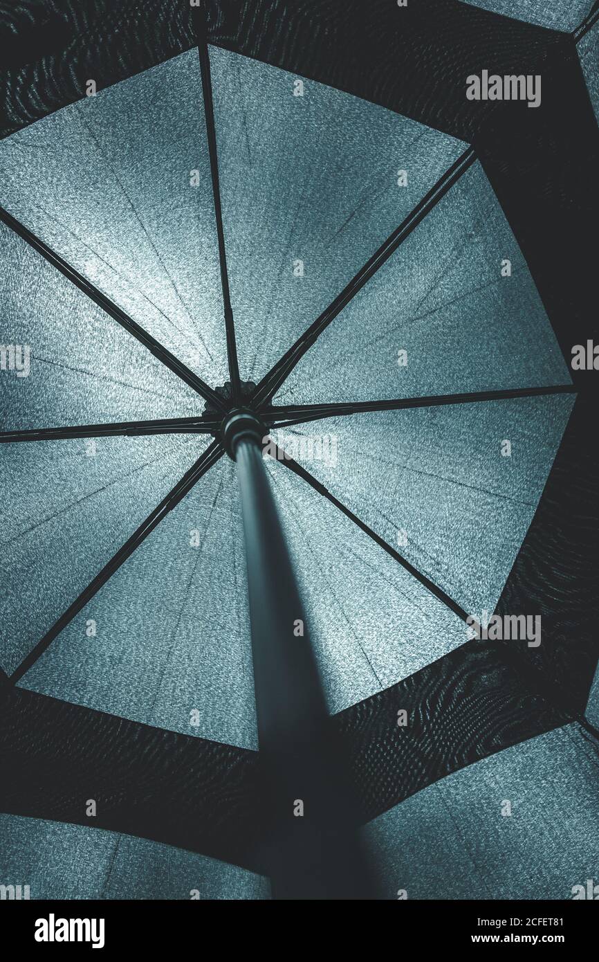 From below view of inside open black umbrella placed against source of ...