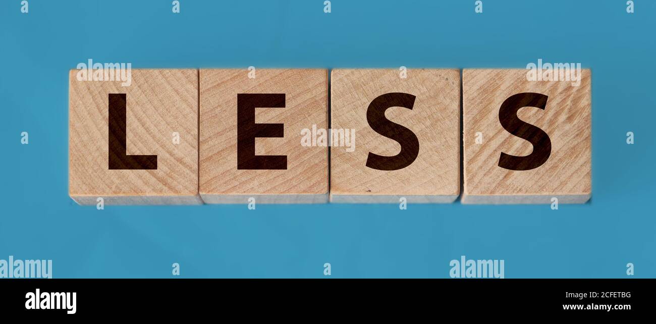 Less word on wooden cubic blocks with letters. cut costs business ...