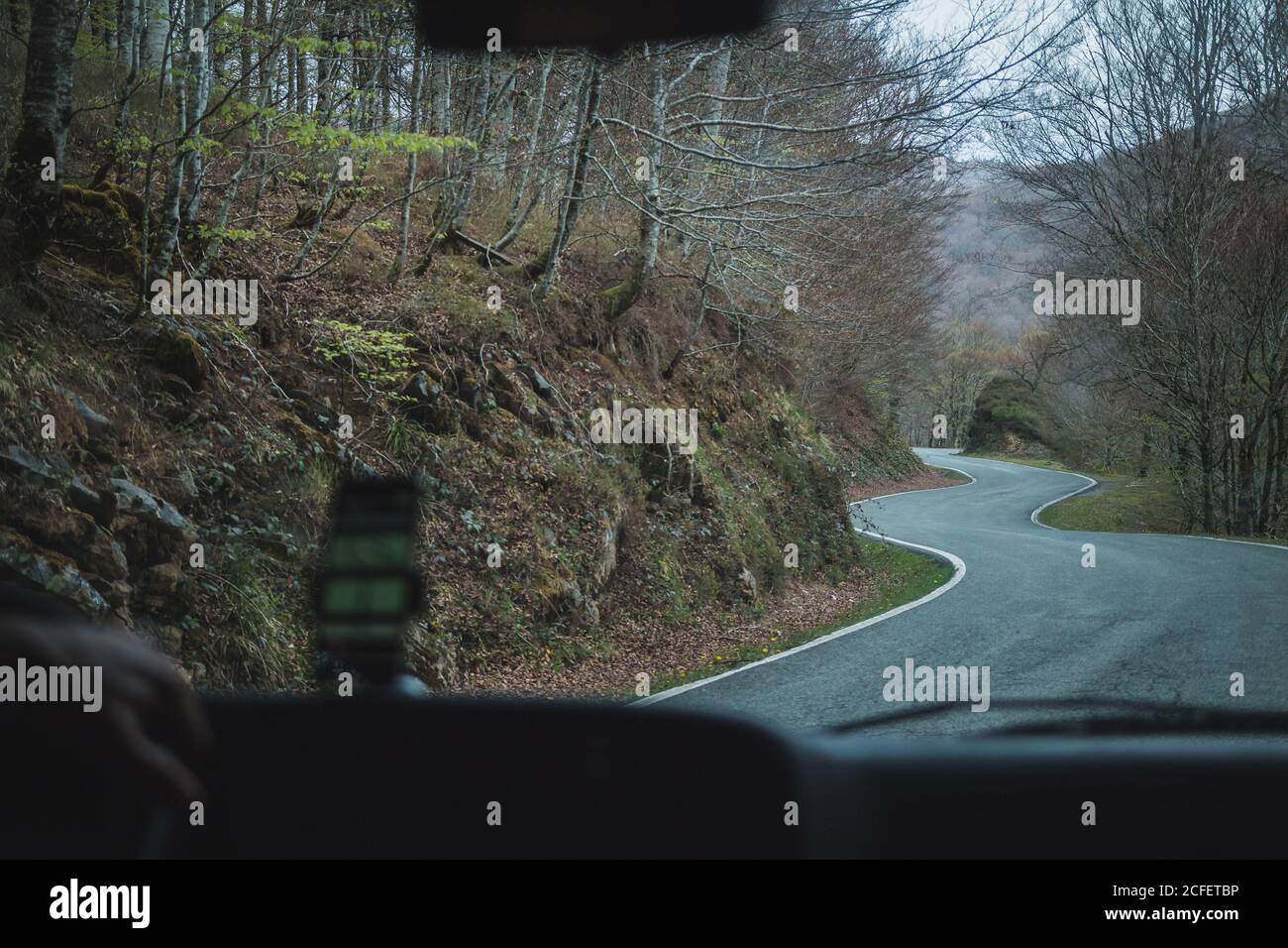 View from inside car of empty road of rural area in overcast weather ...