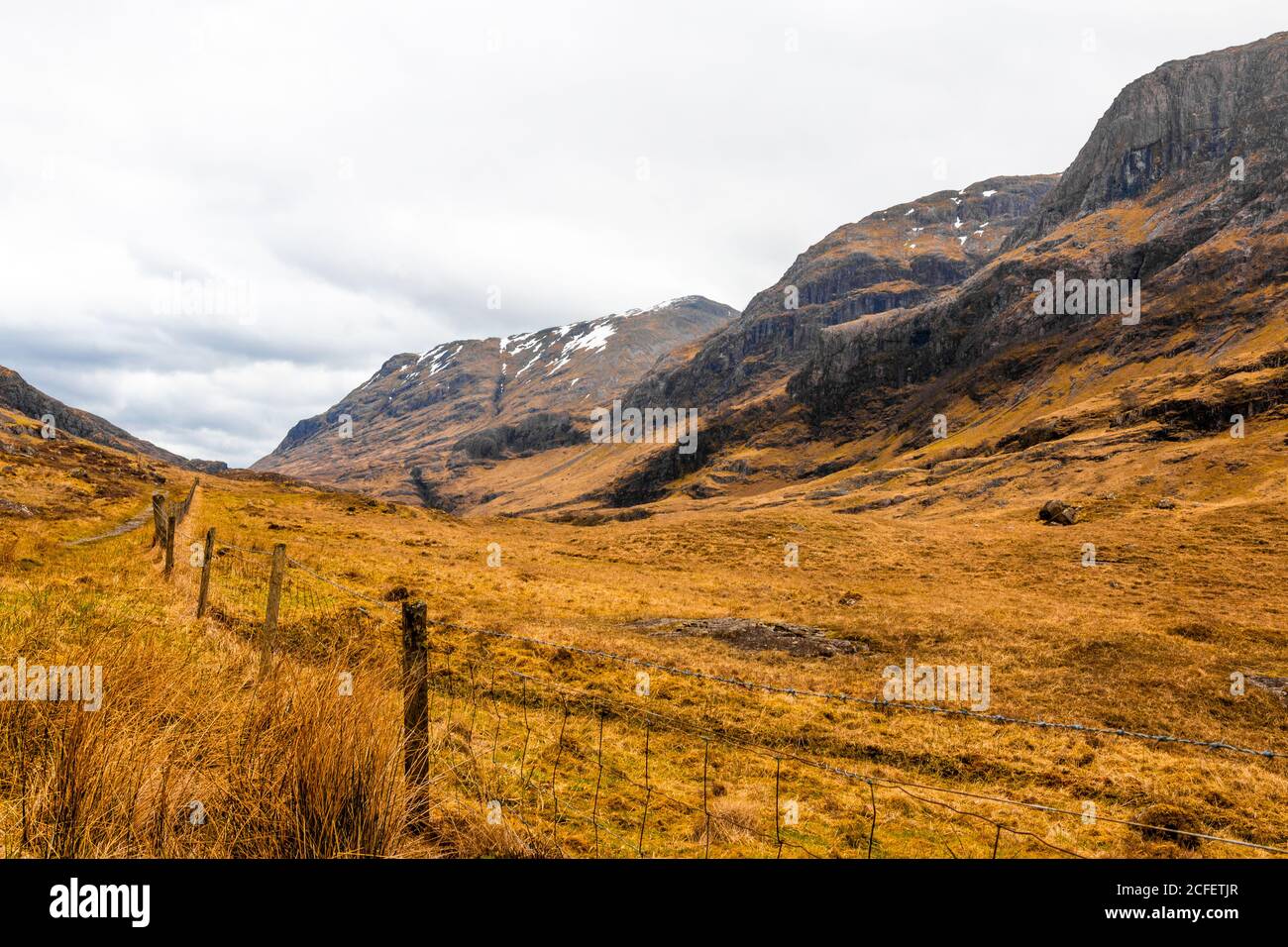 Narrow curvy road running through hilly terrain with dry grass among ...