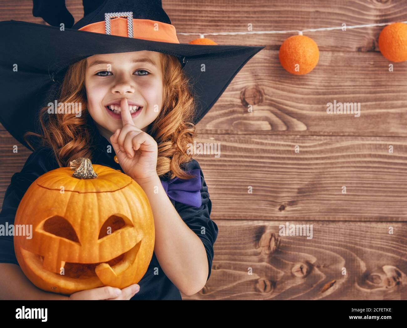 Happy Halloween! Cute little witch with a pumpkin Stock Photo - Alamy
