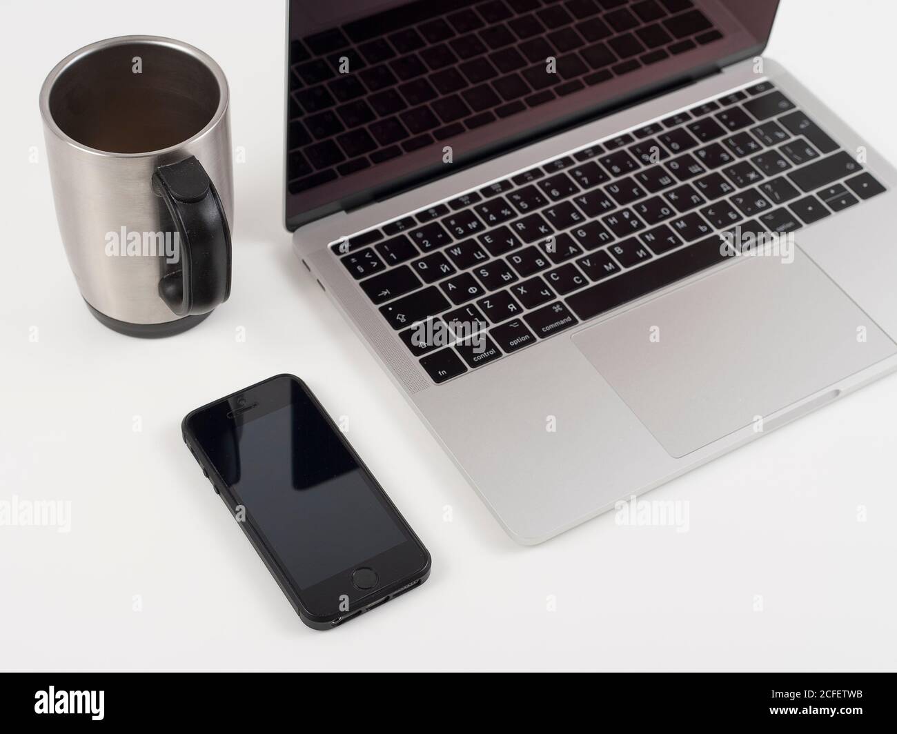 Coffee cup with laptop and cell phone isolated on white background ...