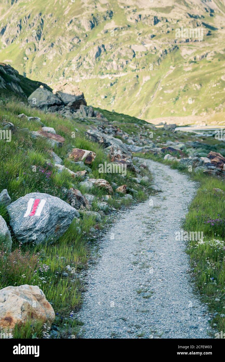 Calm landscape of narrow dirt stone path curving in mountains with ...