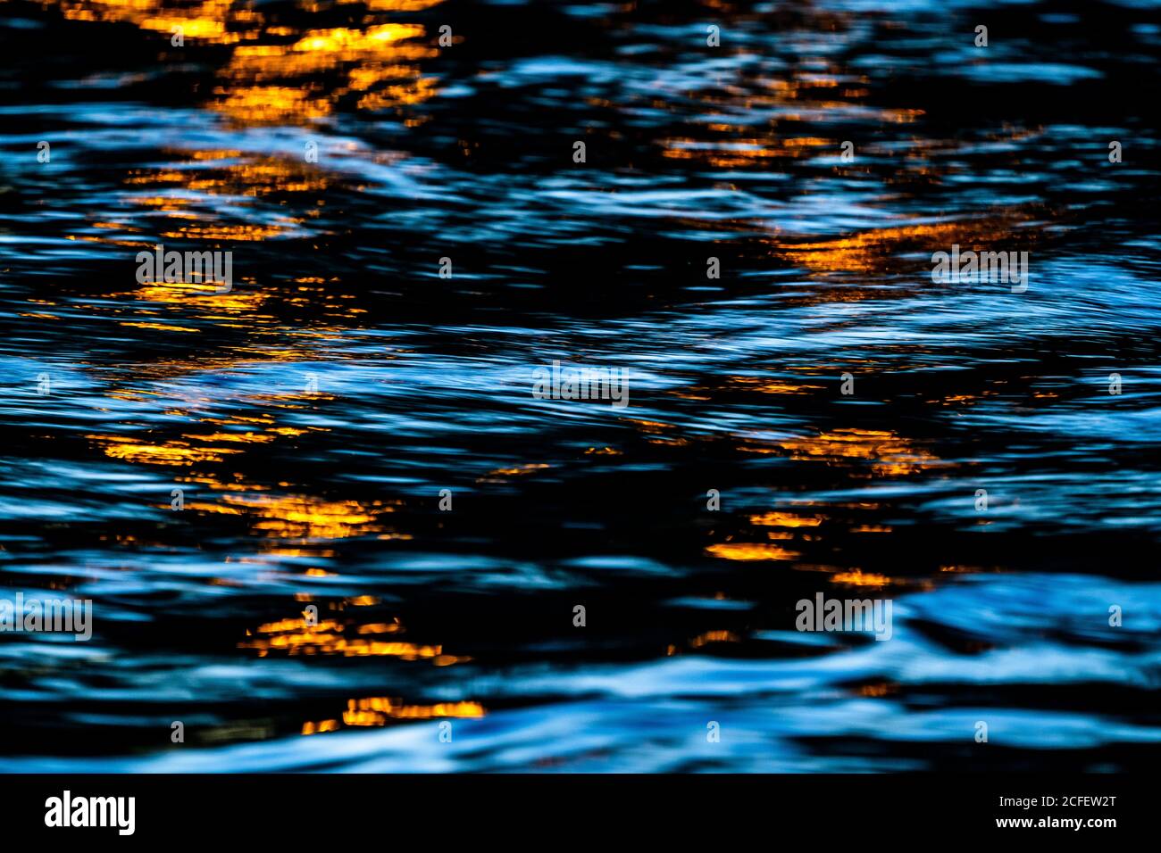 Natural texture and background with dark rippled water reflecting ...