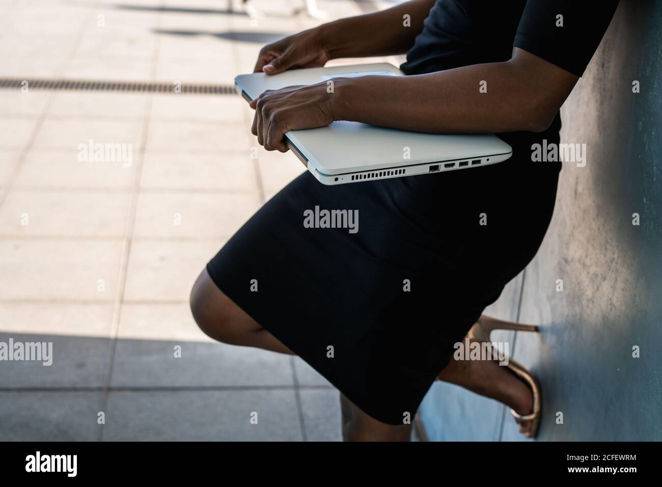 Cool African American smart Woman using a mobile phone holding a laptop ...