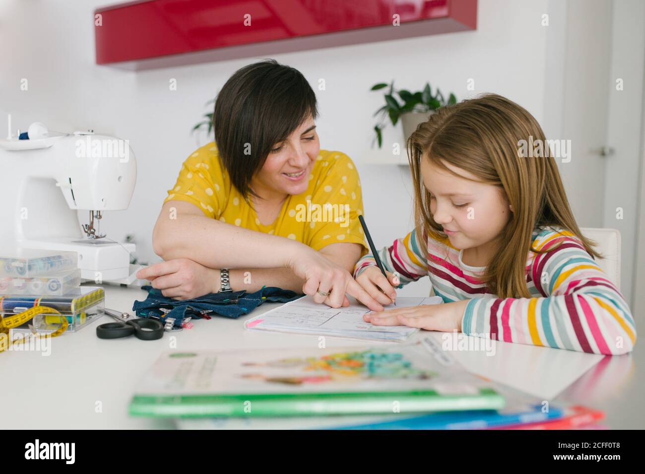 Happy adult Woman smiling and helping girl with homework assignment ...