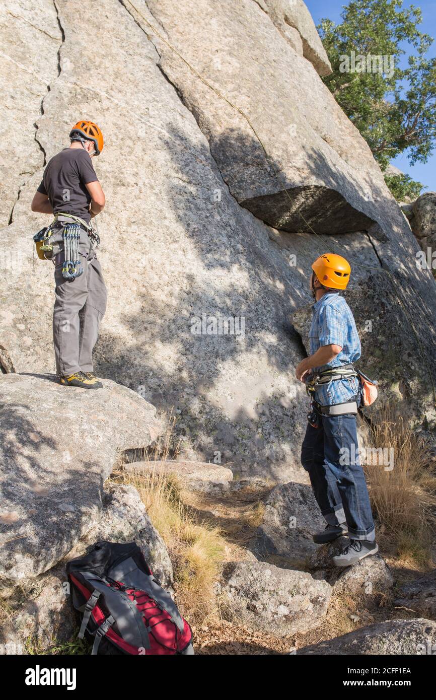 Back view of climbers preparing their equipment to start climbing Stock ...
