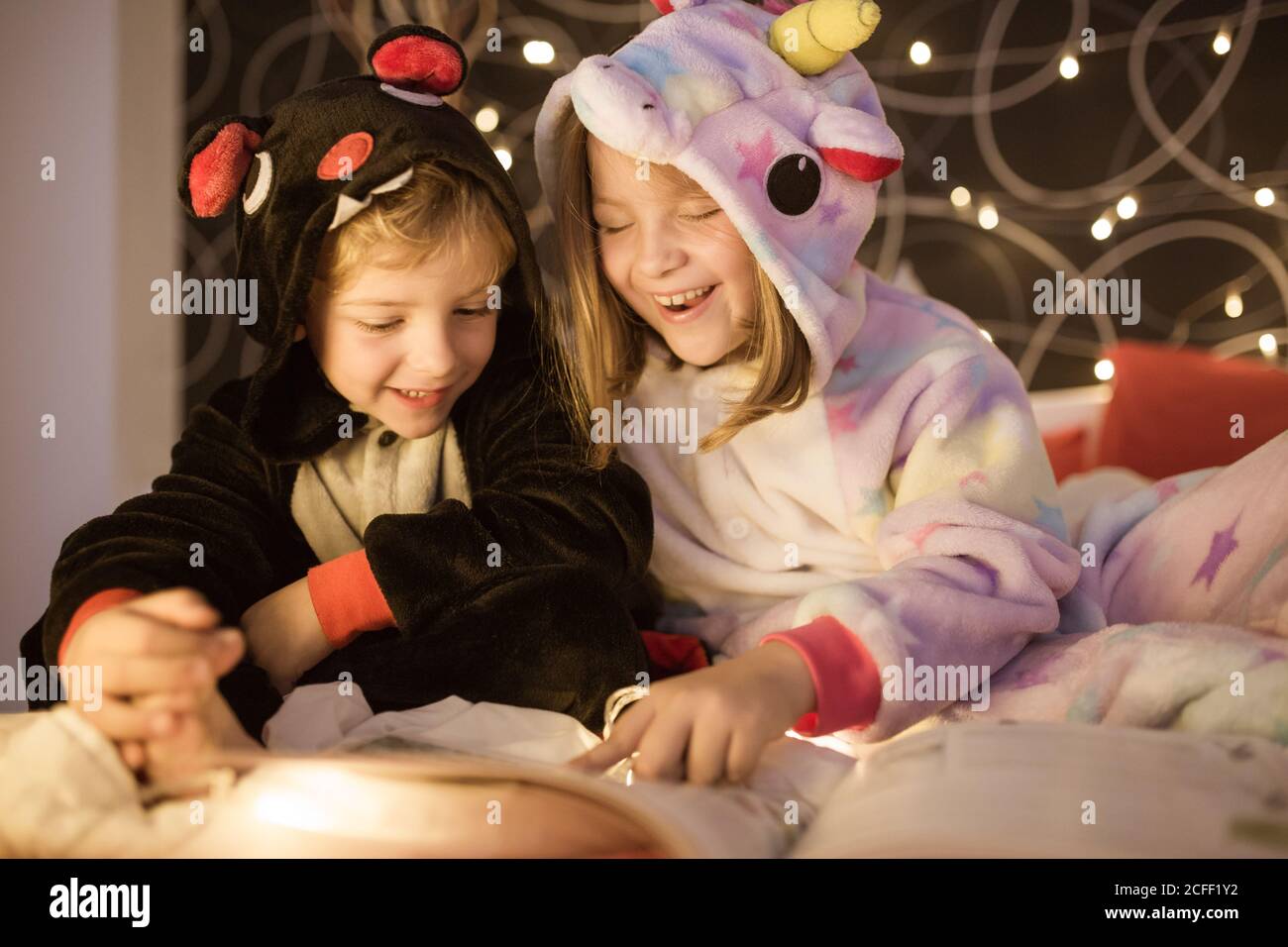 Kids reading Christmas fairy tales in bed Stock Photo - Alamy