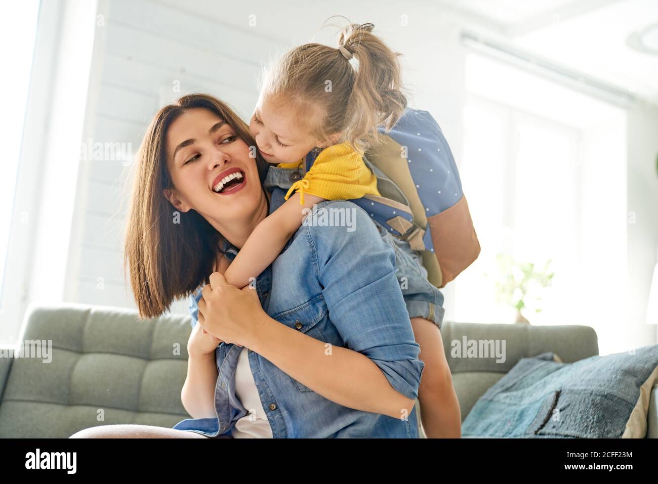 Parent and pupil of preschool. Woman and girl with backpack behind back ...