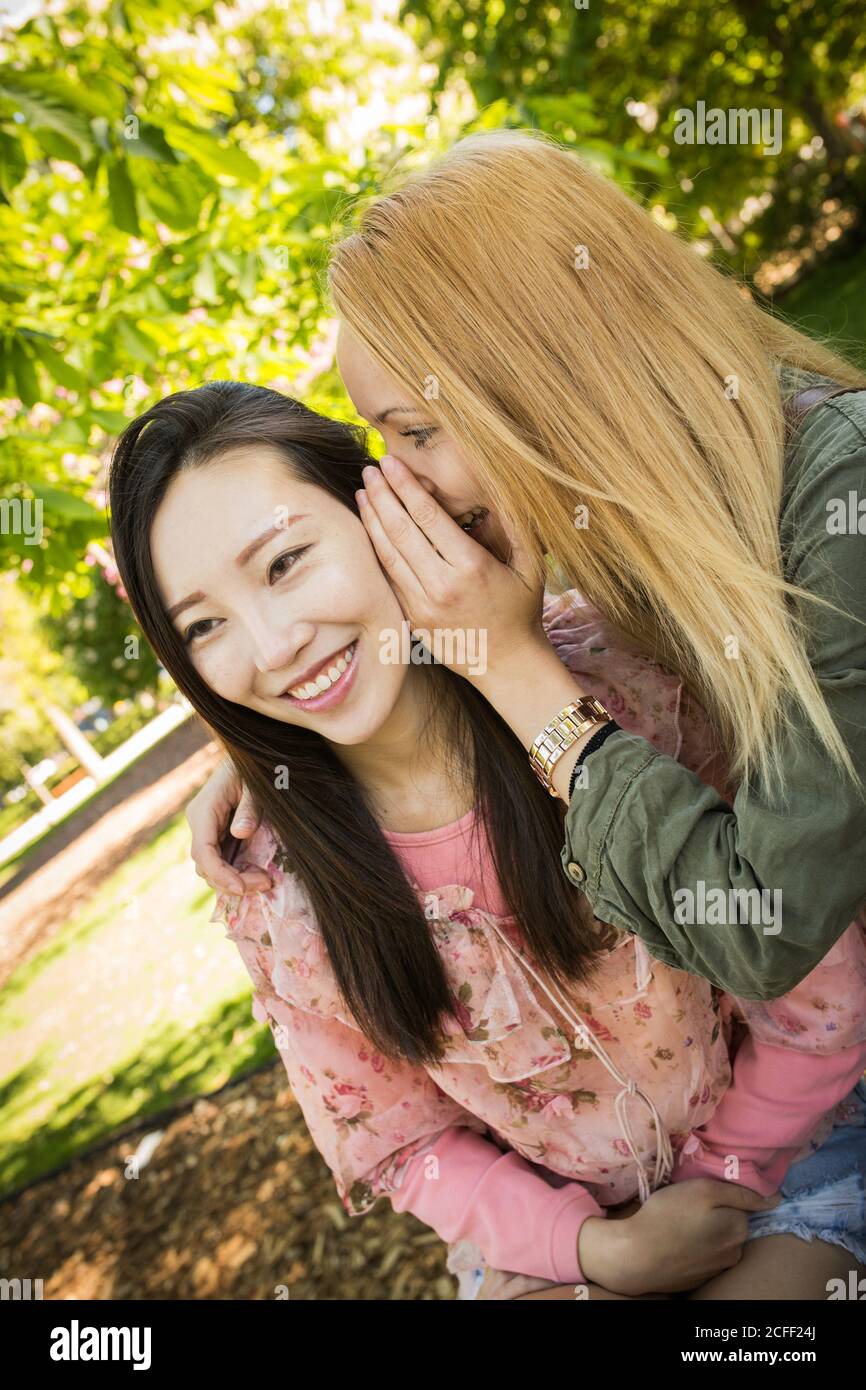 Women whispering in friends ear hi-res stock photography and images - Alamy