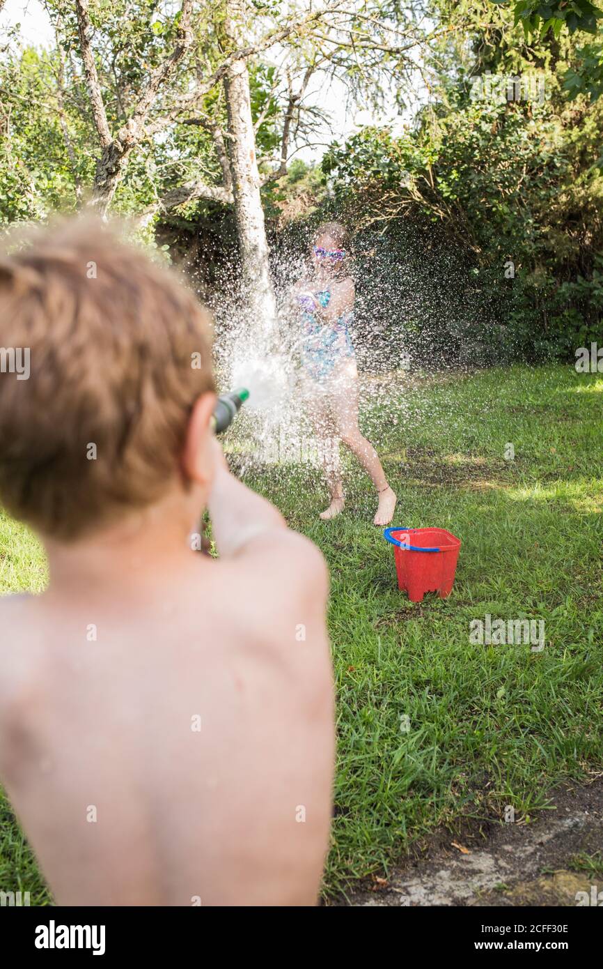 Little children in swimwear running around and splashing water from ...