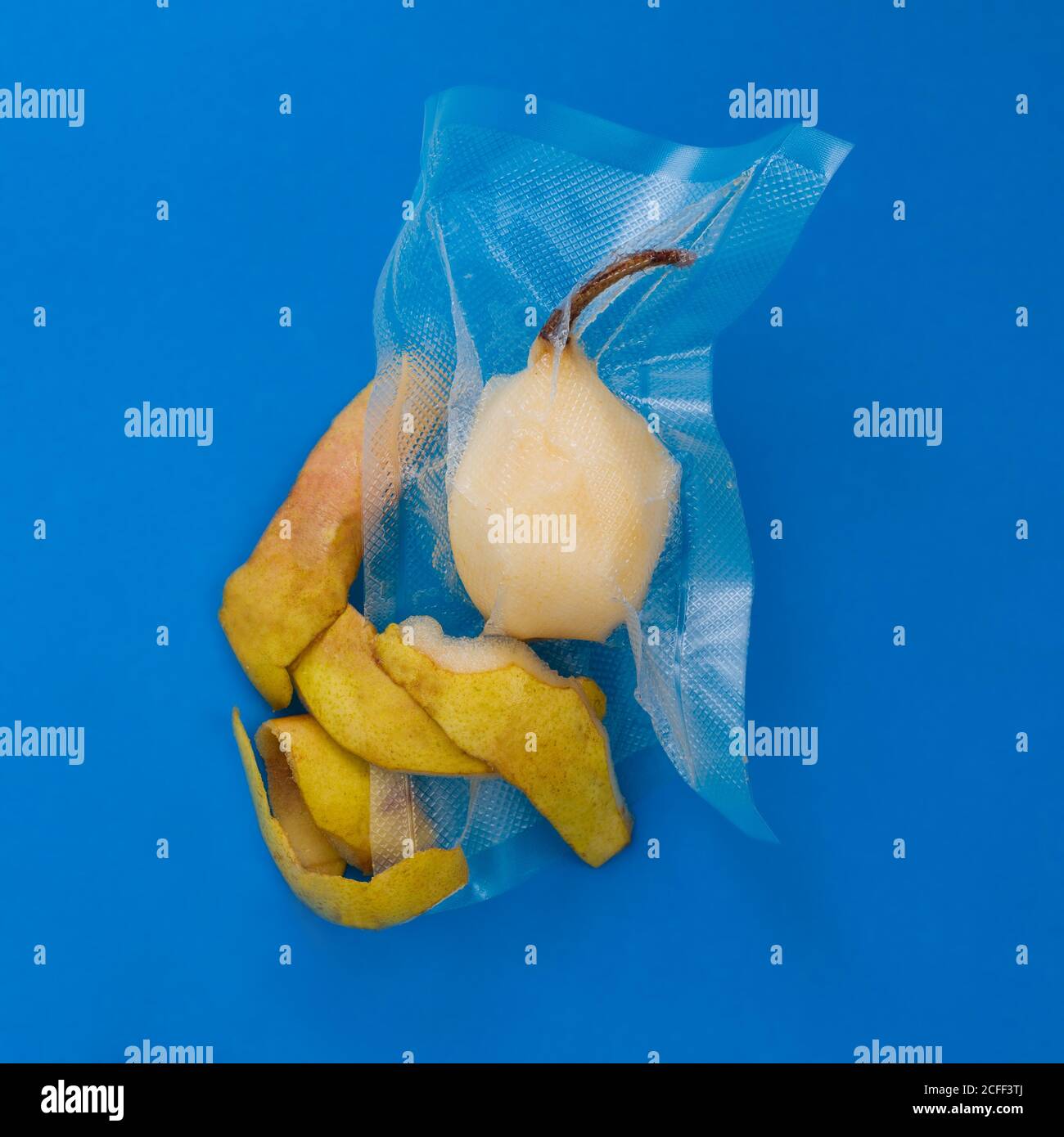 Top view of ripe yellow peeled pear in vacuum plastic bag and pear peel ...