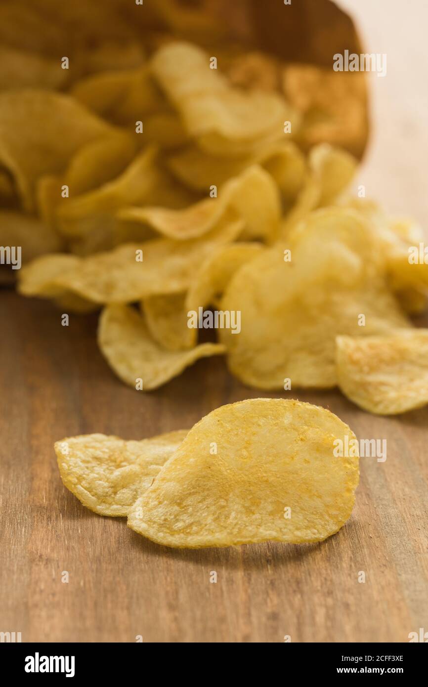 Crispy potato chips placed on wooden table in kitchen Stock Photo - Alamy