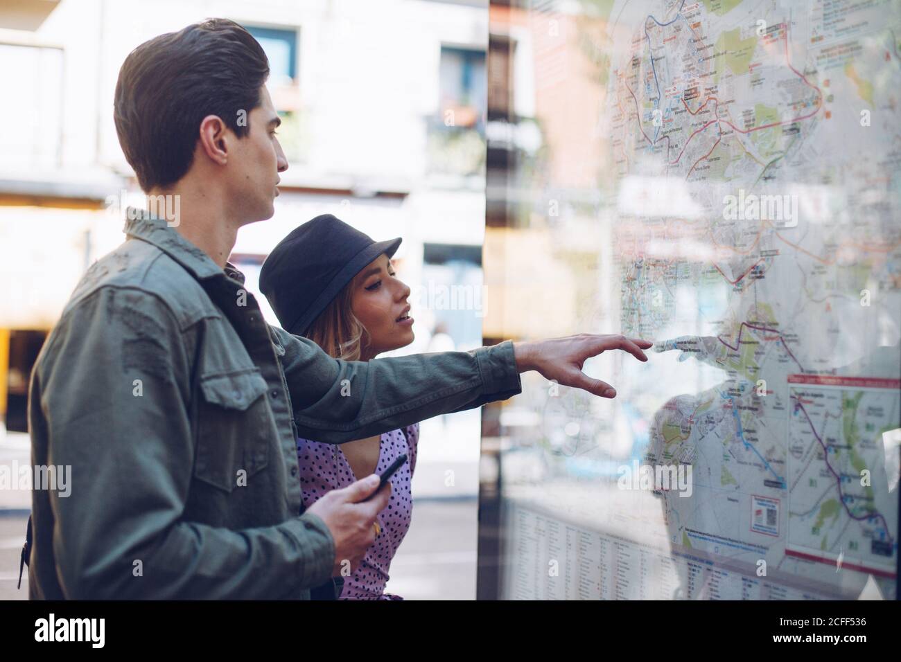Young attractive couple of tourists looking at map in street Stock ...
