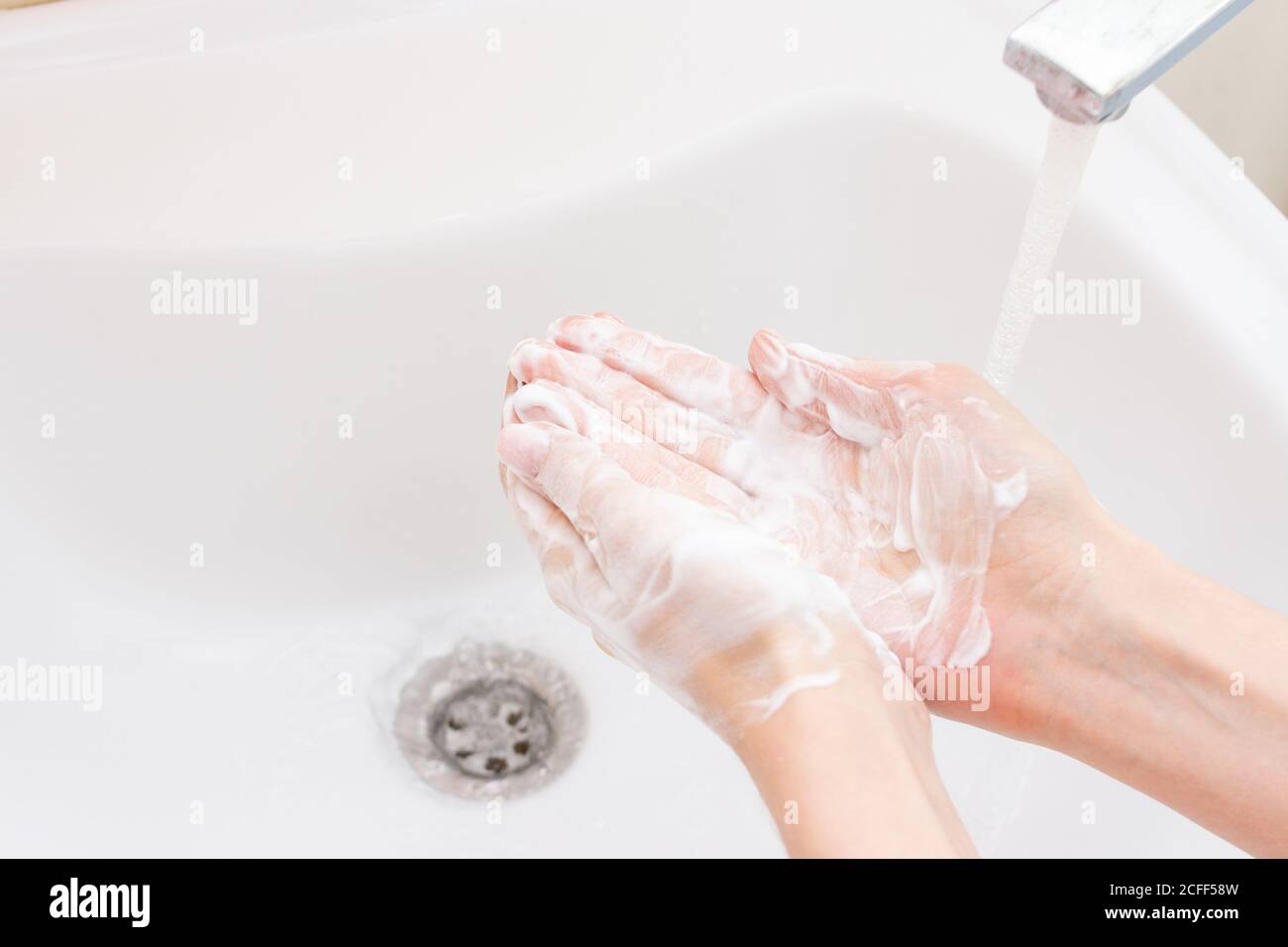 Woman washing hands over sink in bathroom Stock Photo - Alamy