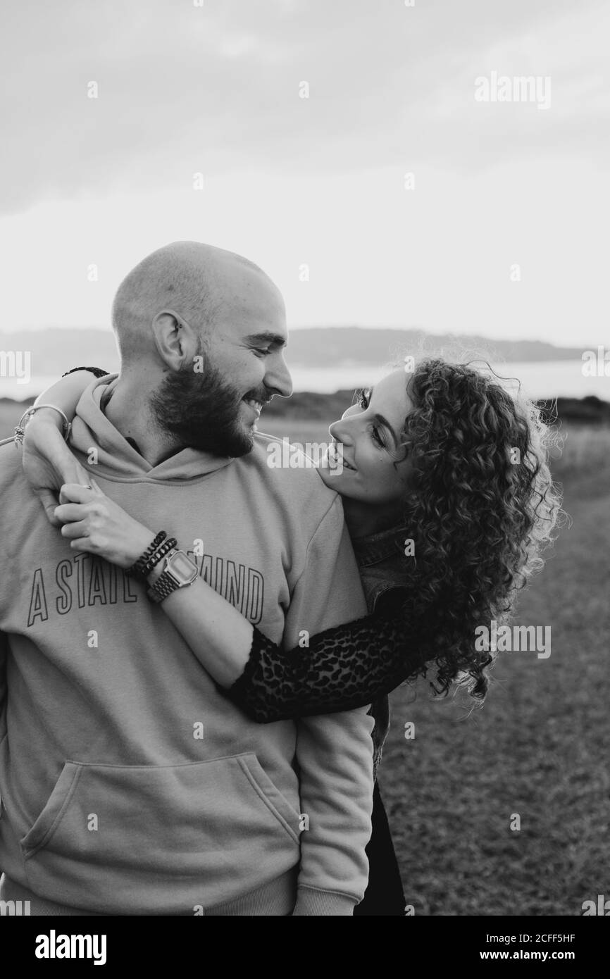 Young bald bearded man in yellow hoodie and jeans shorts being embraced ...
