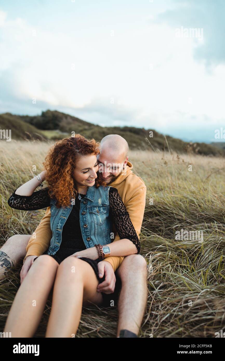Young bald bearded man in yellow hoodie and jeans shorts embracing ...