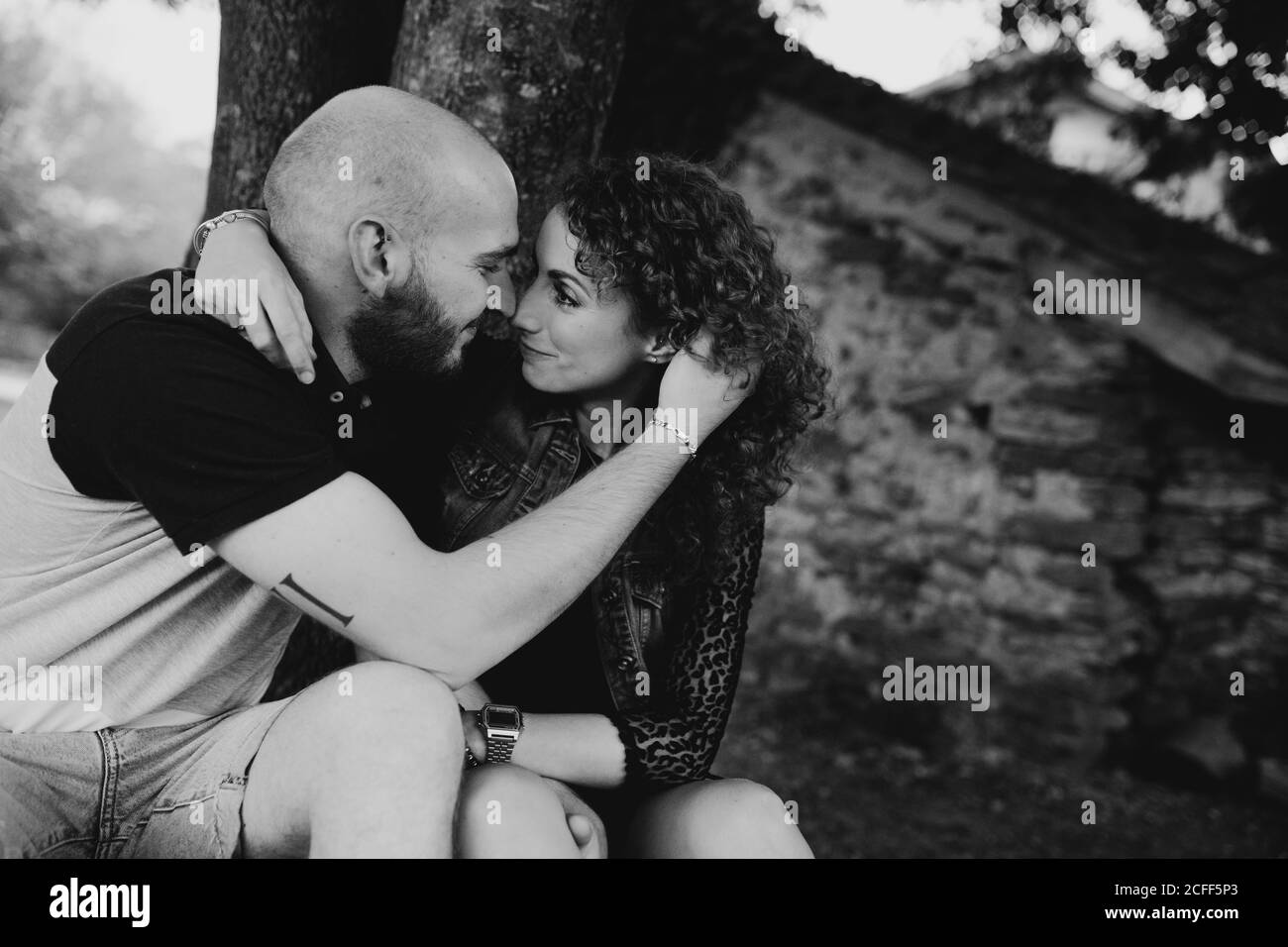 Young bald bearded man in yellow hoodie and jeans shorts embracing ...