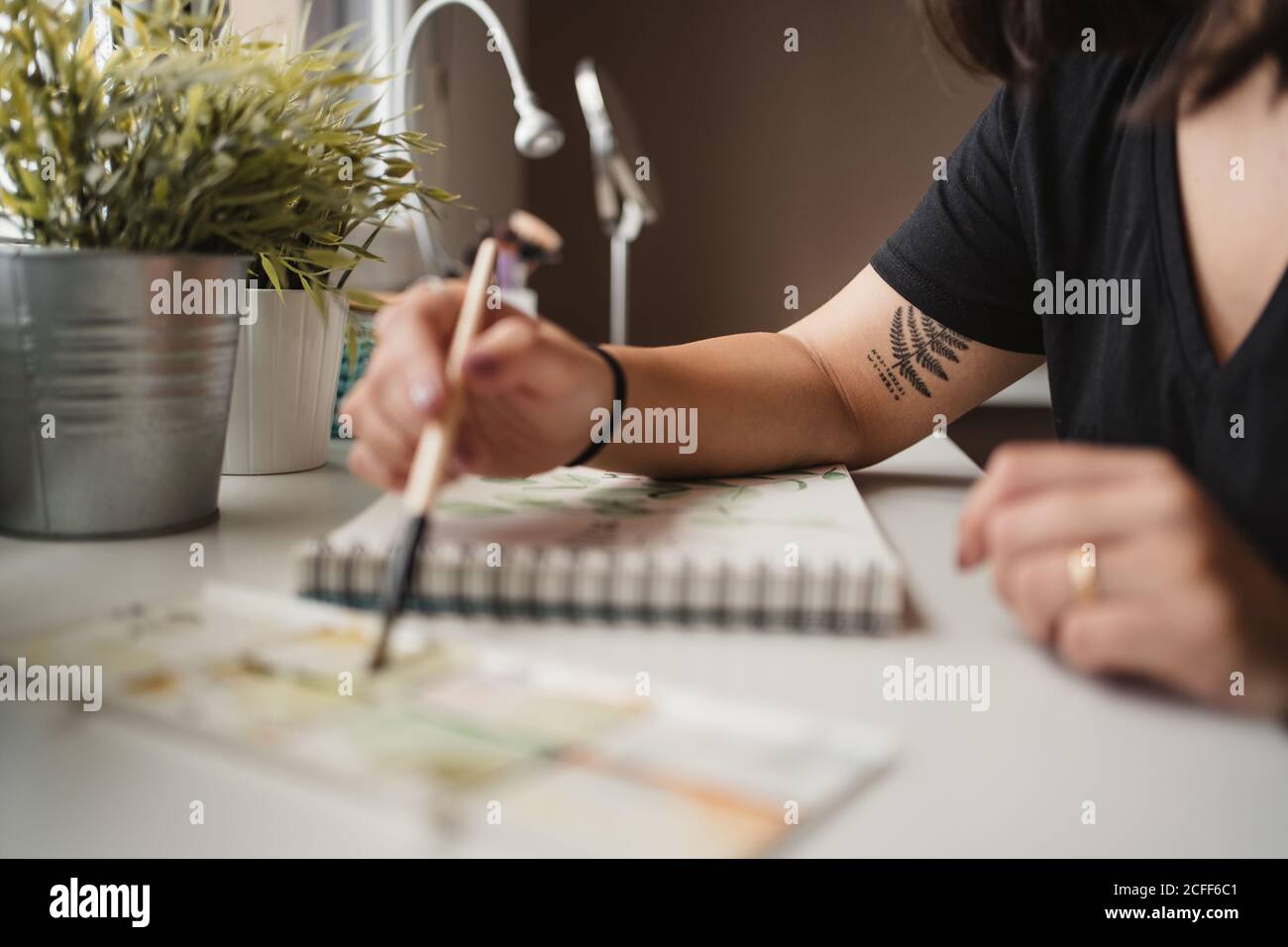 Crop unrecognizable Woman drawing picture with watercolors at home in ...