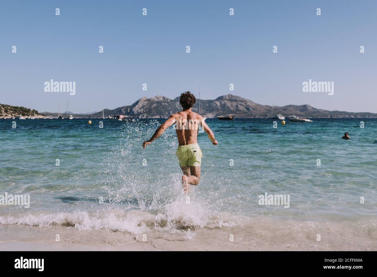 man in swimsuit running in water on seashore Stock Photo - Alamy
