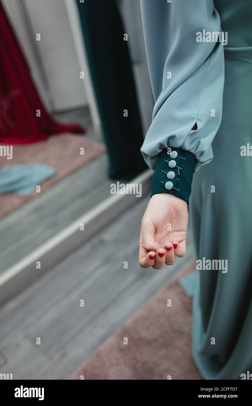 Attached buttons with pins on sleeve of dress on model arm in ...