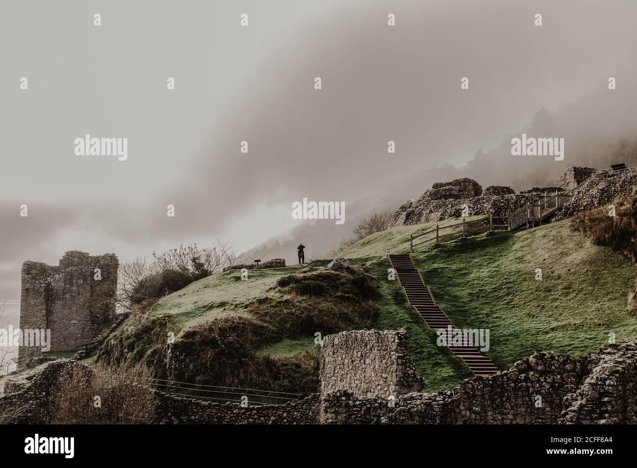 Destroyed old stone castle with fog with walls and stairs with tower on ...