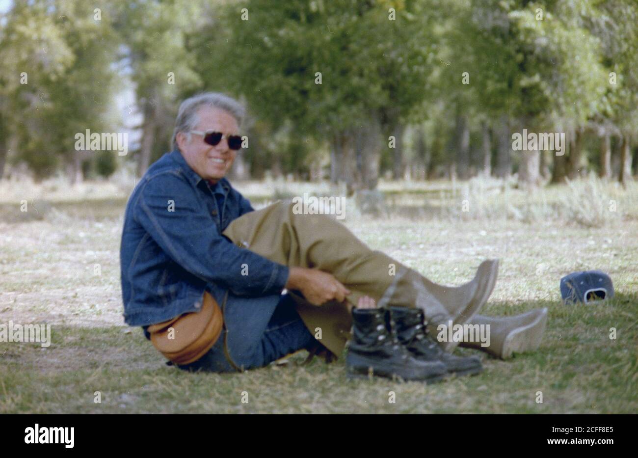 Jimmy Carter putting on his wading boot for fishing ca. 29 August 1978 ...