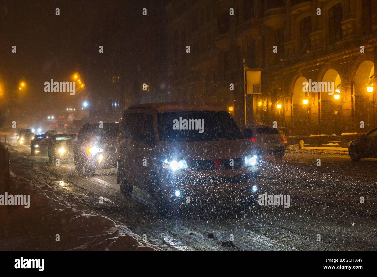 Winter snow storm. Traffic jam at night. Car blurred at the street ...
