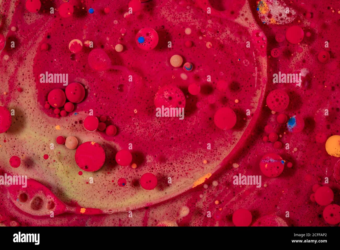 abstract background of multiple bright red bubbles of oil in liquid ...