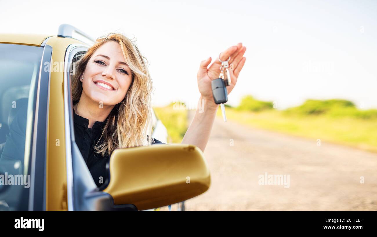 Car purchase or rental. The woman driver shows the key to the car Stock ...