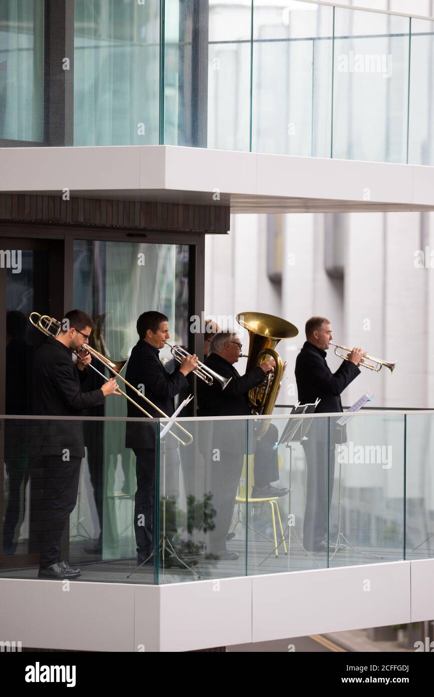 Members of the public watch a surprise appearance by a brass quintet ...