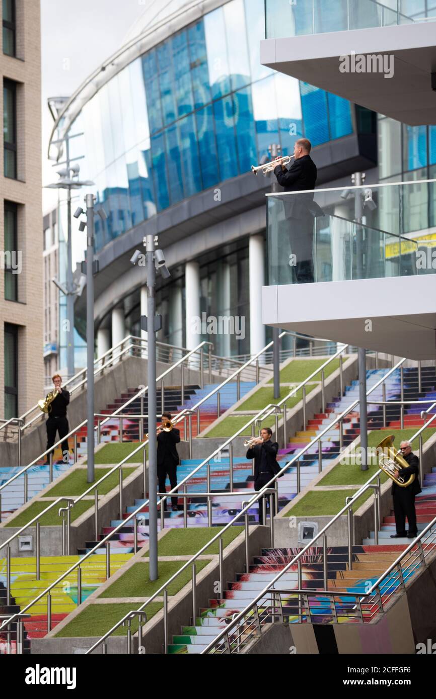 Members of the public watch a surprise appearance by a brass quintet ...