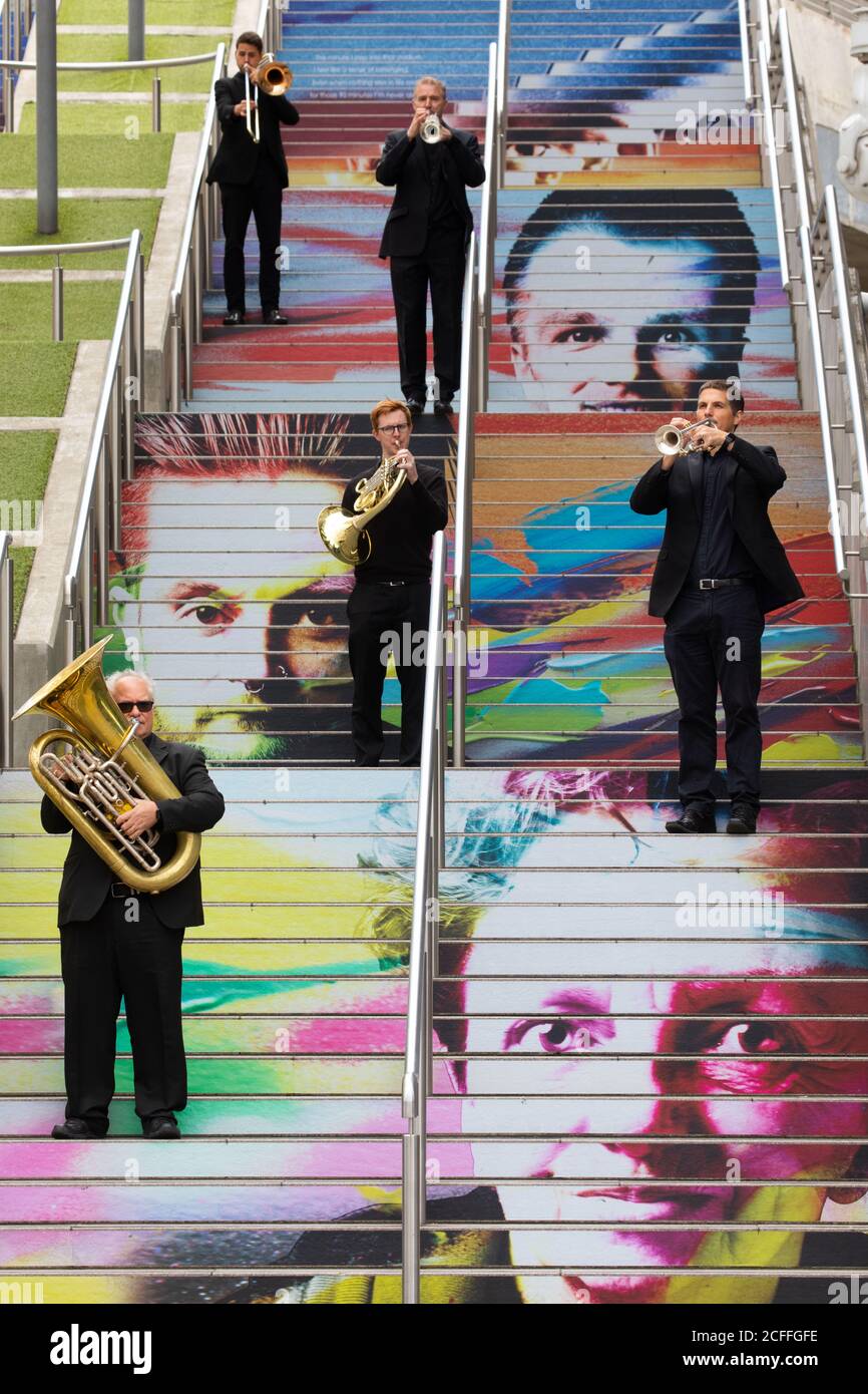 Members of the public watch a surprise appearance by a brass quintet ...