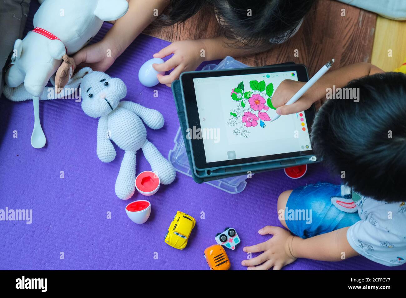 Children drawing image with tablet computer pen while playing in house ...