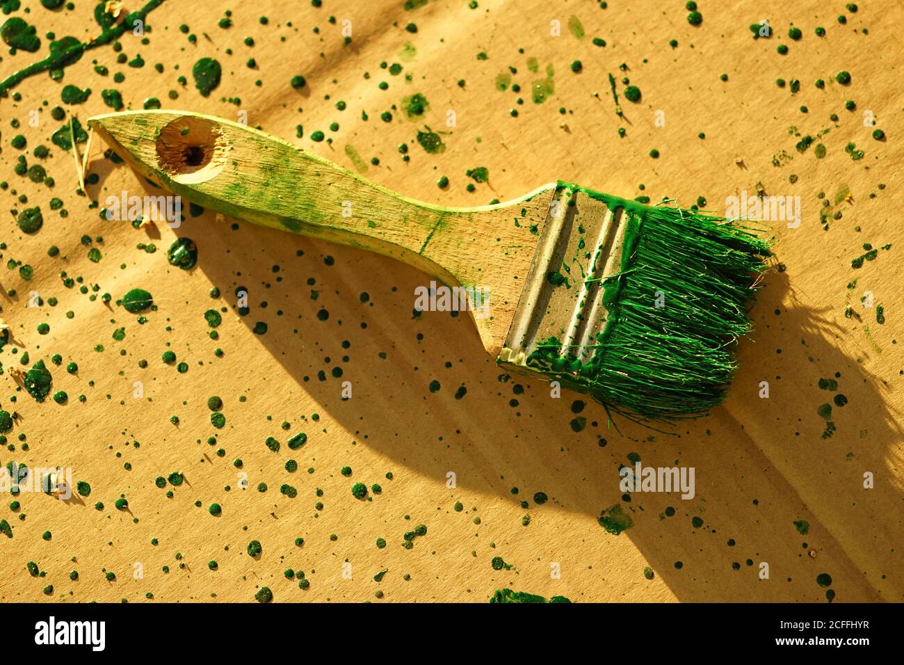 old brush stained with green paint on the dirty brown paper sheet Stock ...