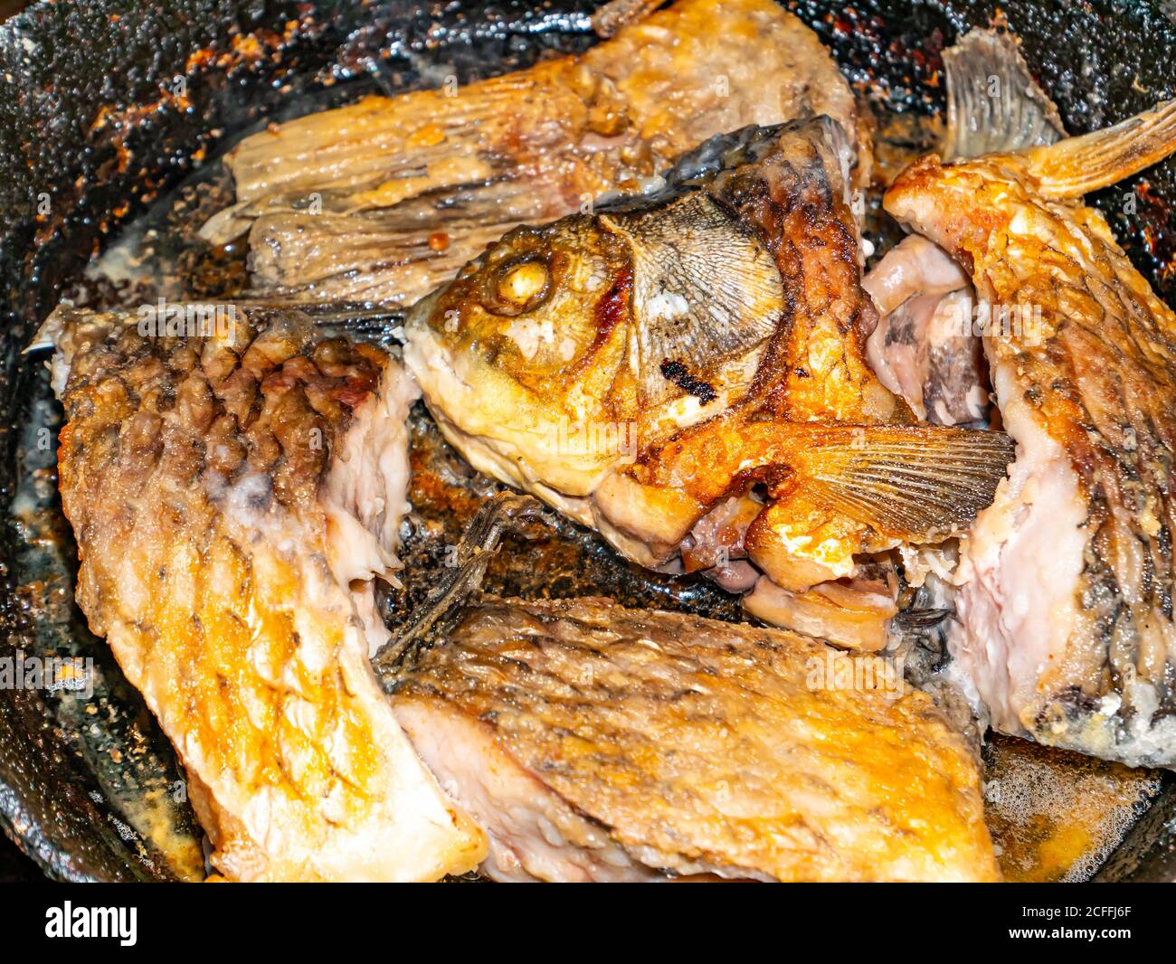 Fish crucian carp is fried in a pan Stock Photo - Alamy