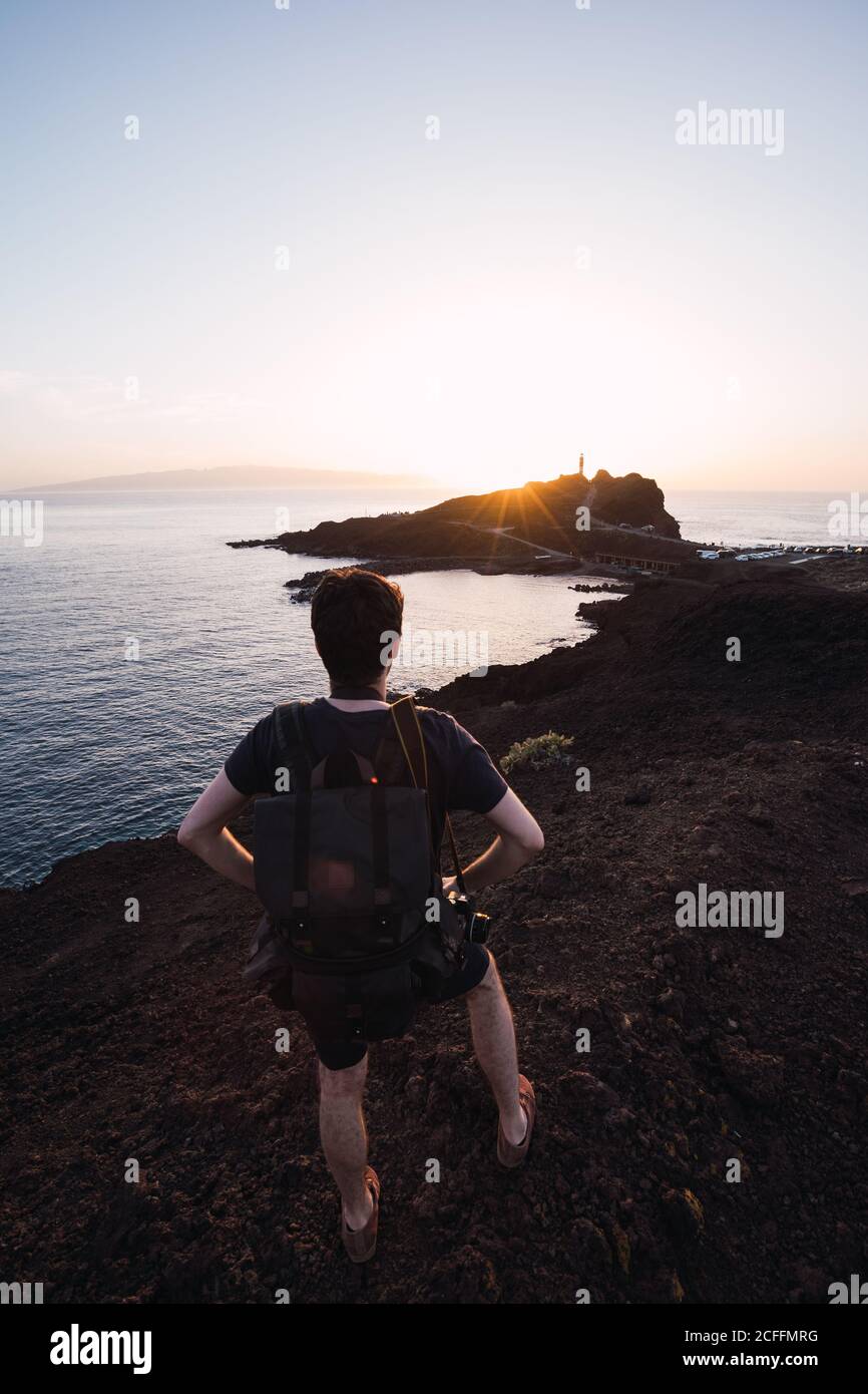 Photographer picturing sunset above remote coast Stock Photo - Alamy