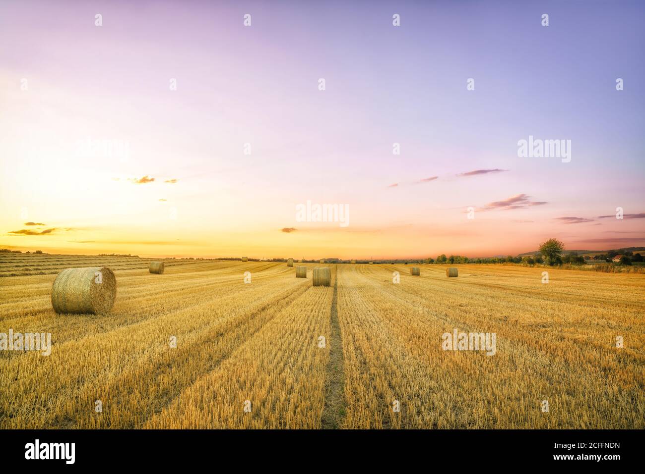 A summer hay field after harvest and large bales of hay on a warm ...