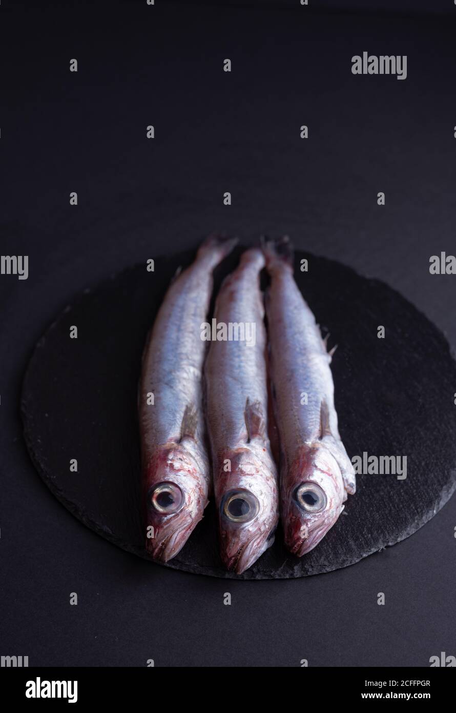 Top view of raw smelt fish placed on black table in kitchen Stock Photo ...