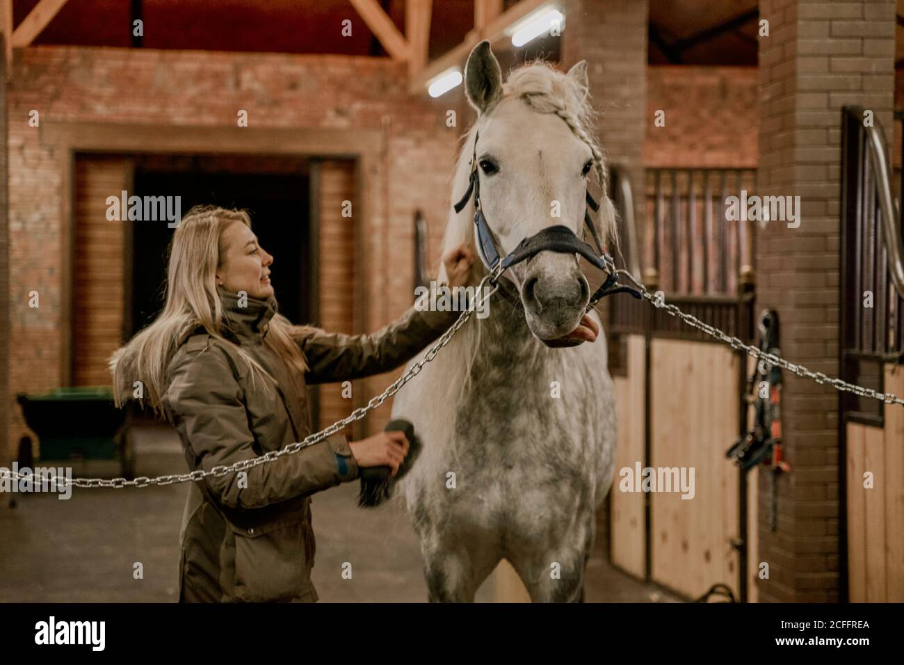 Side view of long haired warm dressed blonde Woman giving food to ...