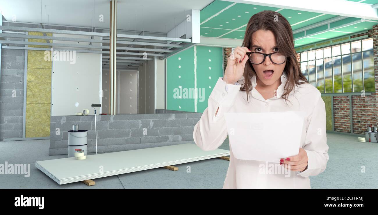 A woman with a shocked expression reading a document in an interior ...