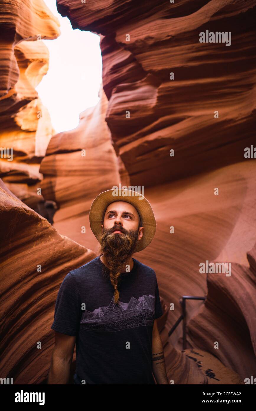 Side view of bearded male examining amazing walls of wonderful ravine ...