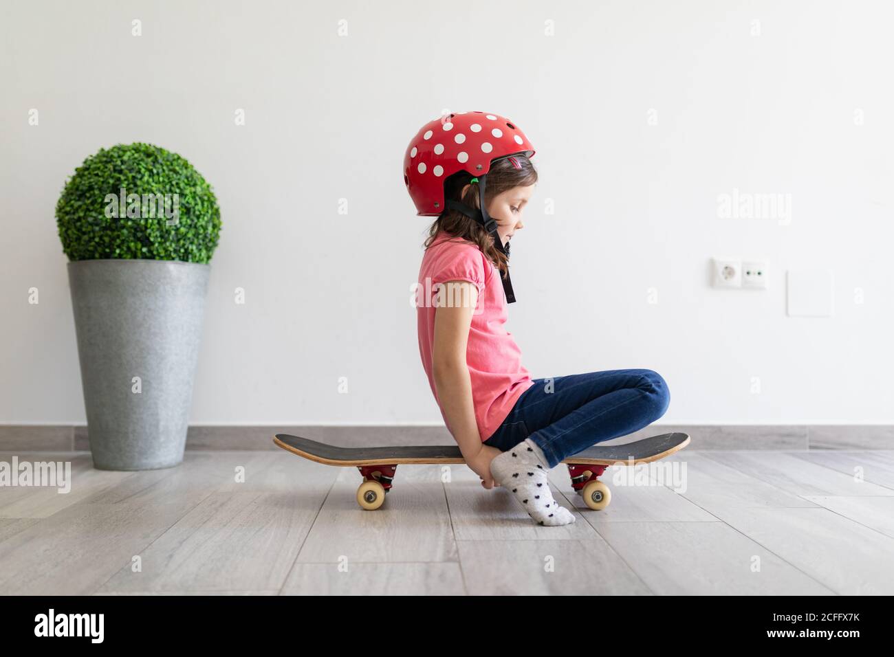 Little kid in red spotted helmet and casual clothes and dreaming about ...